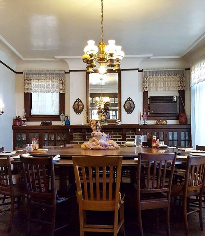 Elegant simplicity defines the dining room, where chandeliers cast a warm glow over wooden tables that have hosted countless memorable meals.