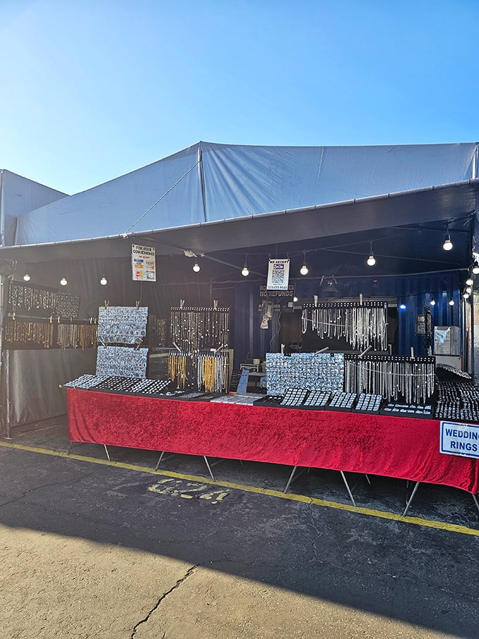 Jewelry displays that sparkle with possibility under string lights. Wedding rings sign suggests life-changing purchases happen alongside impulse buys.