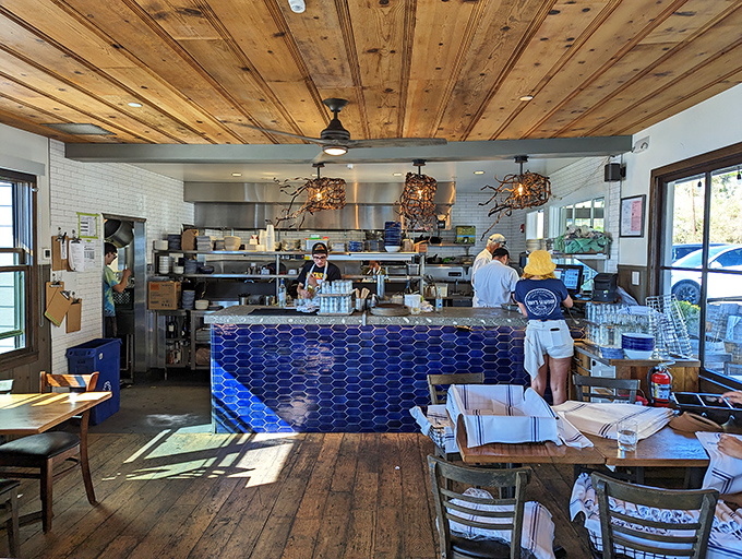 The open kitchen's blue tile counter serves as mission control for seafood perfection, where chefs orchestrate oceanic symphonies.
