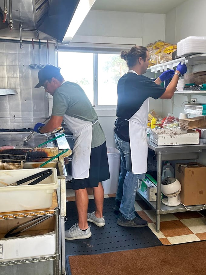 The kitchen ballet &ndash; where burger magic happens with practiced hands and zero pretension, just pure culinary muscle memory.