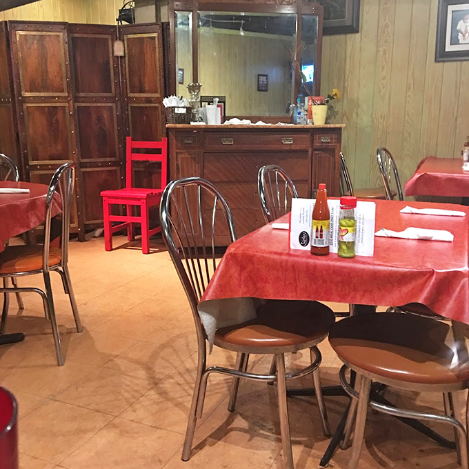 Red tablecloths and simple chairs create a dining room where the food, not the decor, rightfully takes center stage. Southern hospitality in its natural habitat.