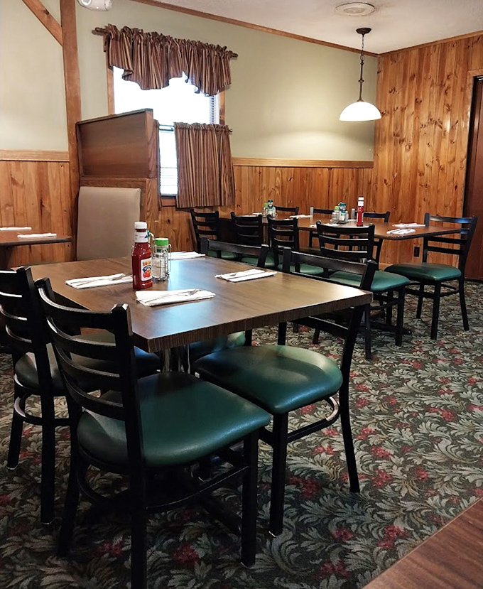 Wood paneling, green chairs, and floral carpet – the dining room trifecta that says "trust us, we know comfort food."