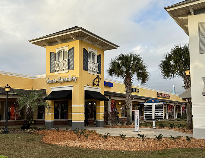 Vera Bradley's corner of the outlets stands like a cheerful beacon of patterned possibility. Palm trees add that perfect touch of coastal shopping paradise.