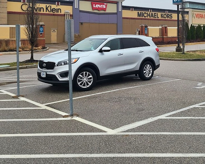 Even the parking lot offers brand-name spotting. That Kia sits proudly between Calvin Klein, Levi's, and Michael Kors—talk about moving up in the world!