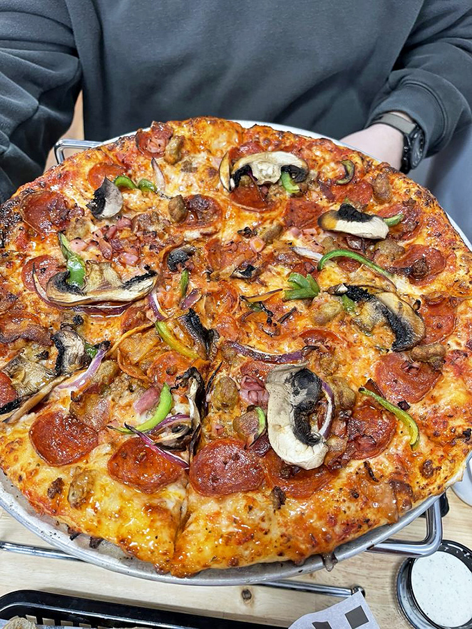 Pizza that doesn't pretend to be Neapolitan but proudly embraces its American heartland roots. Those toppings aren't being shy about their abundance.