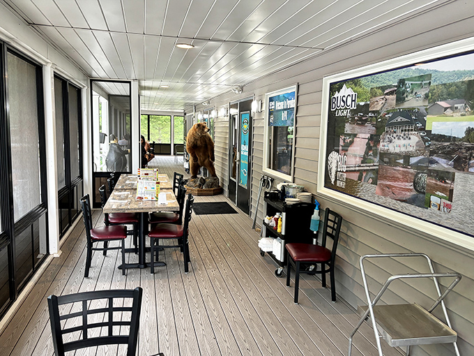Porch seating that offers fresh air, creek views, and a bear statue that's seen more food photos than most Instagram influencers.