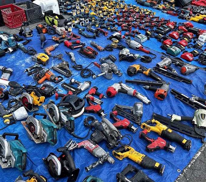 Power tool paradise sprawls across blue tarp&mdash;a DIYer's dream where yesterday's contractors' tools become tomorrow's garage treasures.