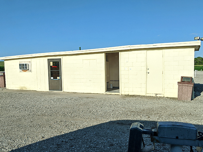 The no-frills restroom building stands ready for intermission rushes. In the drive-in experience, even bathroom breaks become part of the adventure.