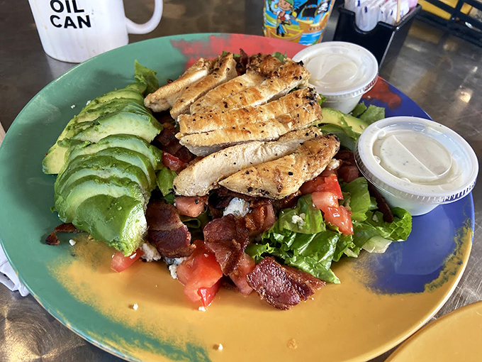 A salad that doesn't apologize for being healthy&mdash;it's too busy showing off with fresh avocado and grilled chicken. The "OIL CAN" mug adds just the right automotive wink.