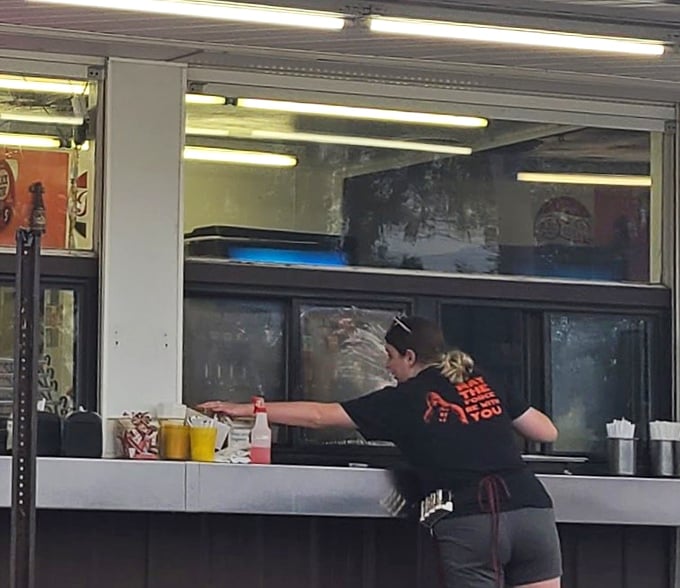 The choreography of a skilled drive-in worker&mdash;where efficiency meets hospitality in a dance that's been perfected over decades.