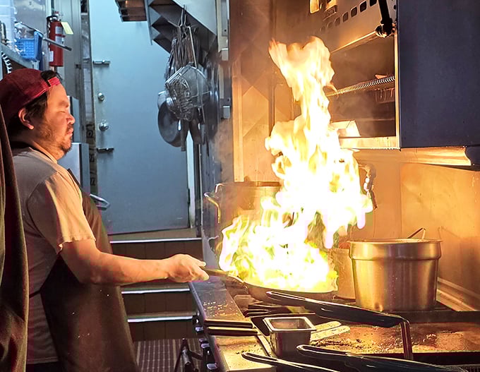 Where the magic happens! The kitchen's dramatic flames are just a hint of the passion that goes into every dish served.
