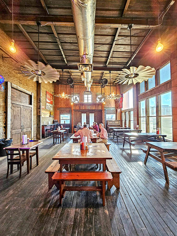 Long communal tables where strangers become friends bonded by smoke, meat, and the universal language of excellent barbecue.