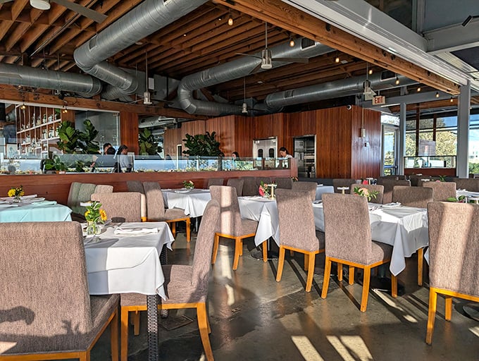 The dining room waits expectantly for the evening rush, tables dressed in white linens like sailors in their Sunday best.