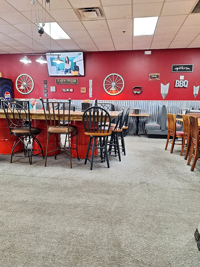 Red walls and wagon wheels create that perfect rustic-meets-roadhouse vibe – where BBQ signs remind you why you came in the first place.