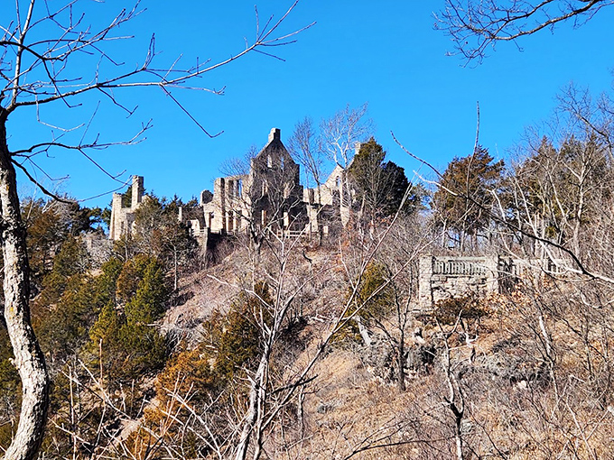 Winter reveals what summer conceals. The bare trees frame the castle ruins in stark relief against the brilliant blue Ozark sky. 