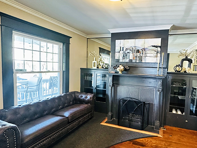 A cozy waiting area featuring a leather couch and original fireplace—architectural details that whisper stories of the building's past while you anticipate your meal.