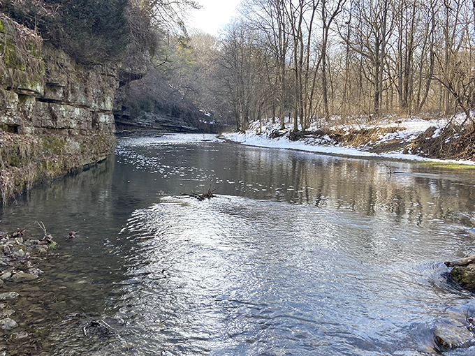 Winter transforms the canyon into a hushed wonderland where the river whispers secrets beneath a delicate layer of ice.