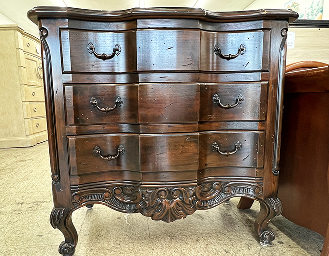 This ornate wooden dresser has stories to tell. Mid-century craftsmanship waiting for its second act in your bedroom.