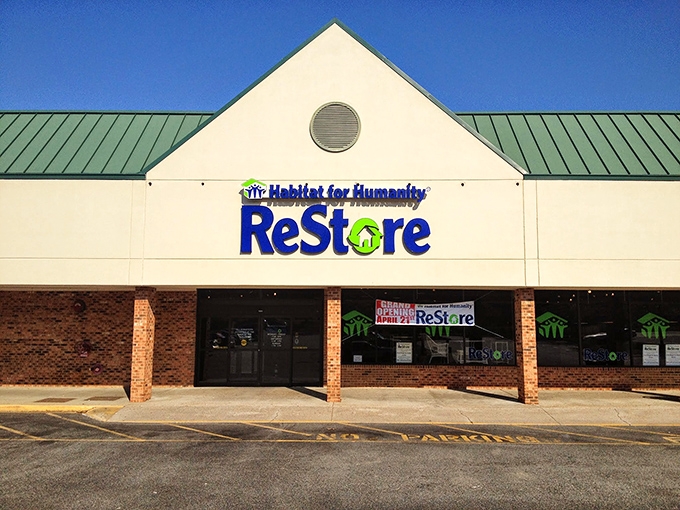 Green roof, blue skies, red-hot deals! Habitat ReStore's charming gabled entrance celebrates its grand opening with architectural flair.