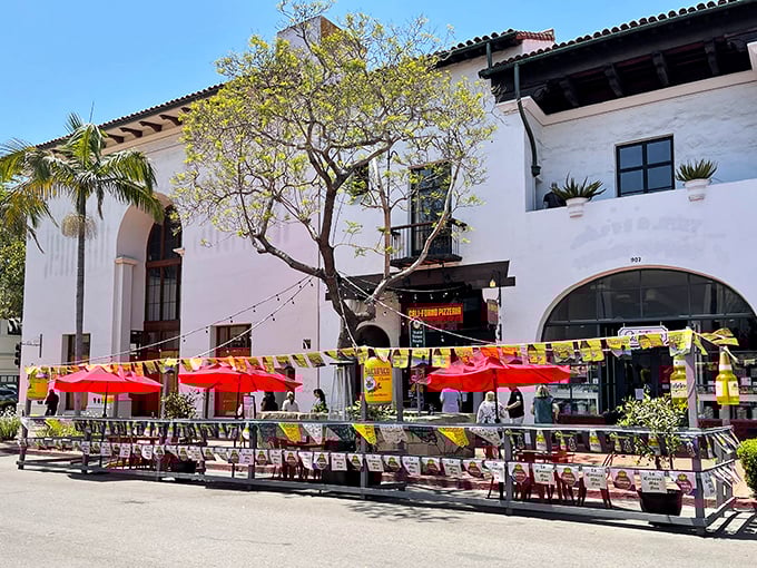 Bright red umbrellas and outdoor seating create the perfect Santa Barbara pizza experience at Cali-Forno's charming location.