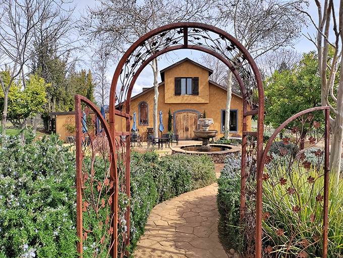 This Mediterranean-inspired vineyard estate, framed by a rustic metal archway, transports visitors to Tuscany without the hassle of international travel.