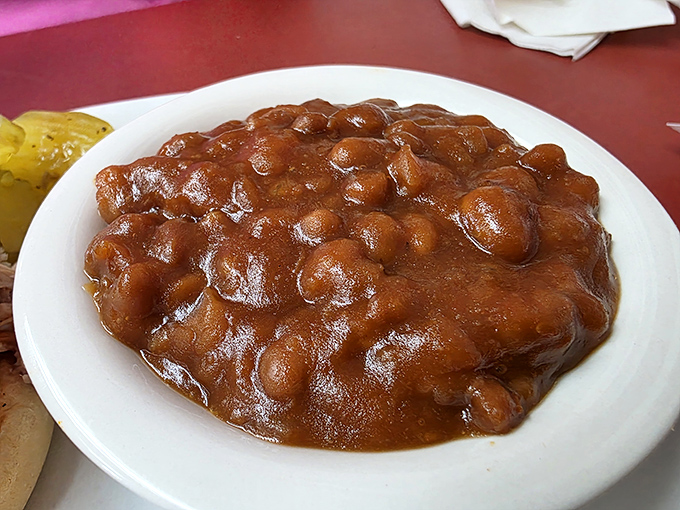 These baked beans have clearly been simmering since breakfast, soaking up smoky wisdom from generations of pit masters.