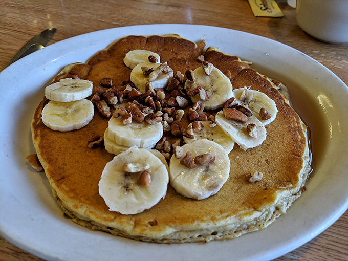 Pancakes topped with banana slices and pecans – nature's candy meeting breakfast's canvas in perfect harmony.