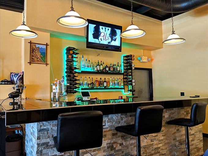 The bar area glows with possibility, bottles standing at attention like soldiers guarding liquid treasures from across the globe.