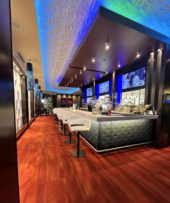 The bar gleams with blue-lit sophistication, a perfect harbor to dock yourself before or after navigating the seafood seas of the main dining room.