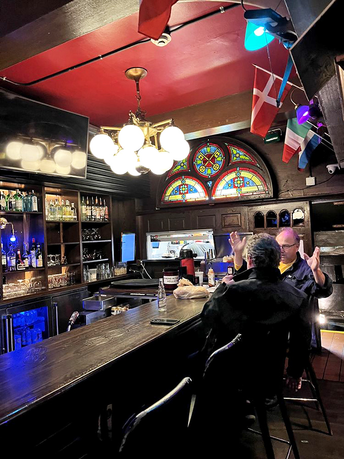 The bar isn't just serving drinks&mdash;it's a command center with stained glass windows and international flags standing by for your next mission.