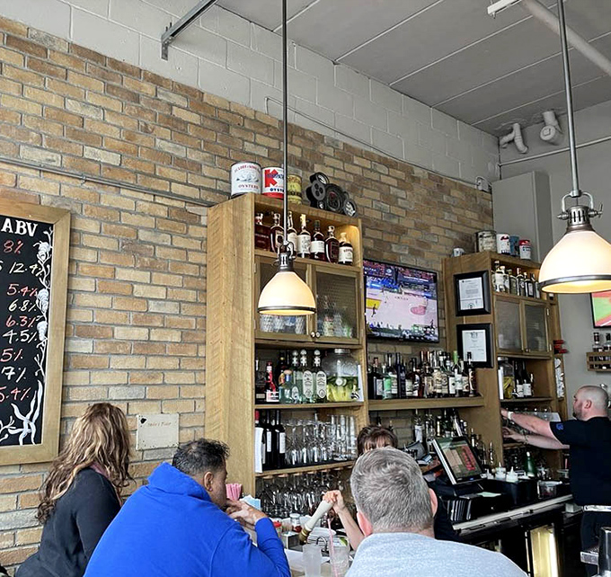 Behind the bar, bottles stand at attention like soldiers guarding liquid treasures, while patrons gather for the daily ritual of happy conversation.