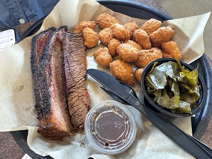 Brisket with the perfect smoke ring alongside golden corn fritters&mdash;a plate that makes vegetarians question their life choices.