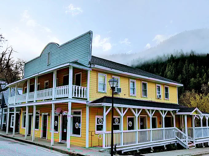 The yellow building glows against misty mountains, a Gold Rush-era structure reimagined for modern comfort while honoring its storied past.