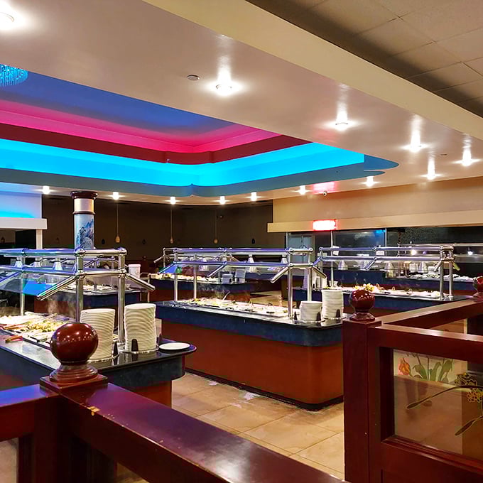 Buffet stations bathed in dramatic blue and pink lighting create an almost theatrical dining experience. Your plate is waiting for its starring role.