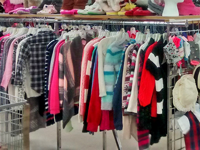 The children's section: where tiny plaids and pastels hang like colorful promises of playground adventures yet to come.