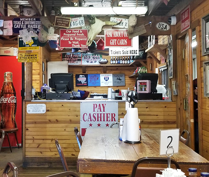 At the counter, where transactions are straightforward and the decor proudly declares its Texas heritage without a hint of irony.