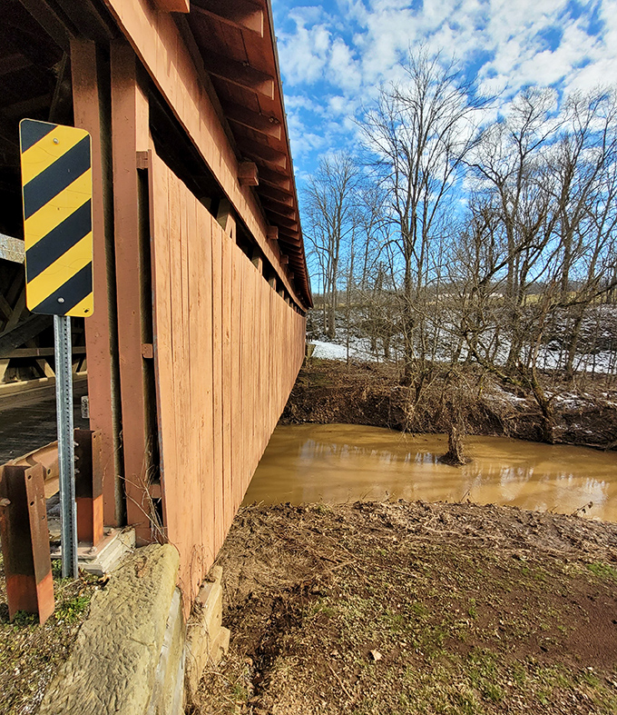 From this angle, you can almost hear the gentle murmur of the creek as it flows beneath weathered planks that have witnessed generations.