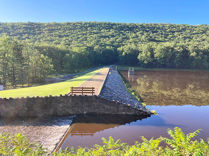 Engineering meets nature at Poe Valley's dam. This human-made marvel creates the perfect mirror for Pennsylvania's rolling green mountains.