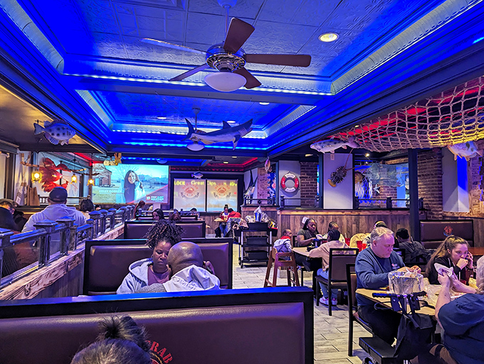 Diners settle into comfortable booths under blue lighting, where the serious business of seafood enjoyment unfolds without judgment or pretense.