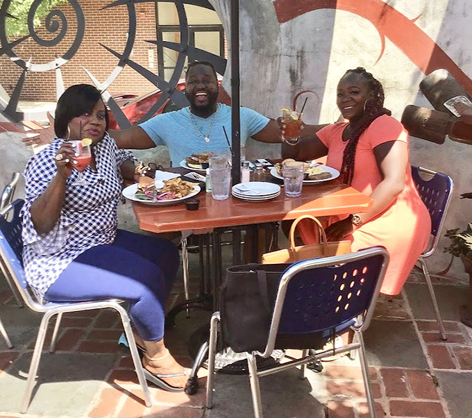 Happy diners in the outdoor space, raising glasses to good food, good company, and the universal truth that calories don't count when you're making memories.
