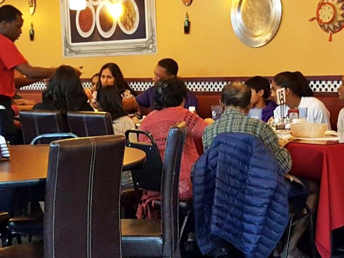 Happy diners sharing platters family-style &ndash; because the only thing better than discovering amazing food is introducing friends to it.