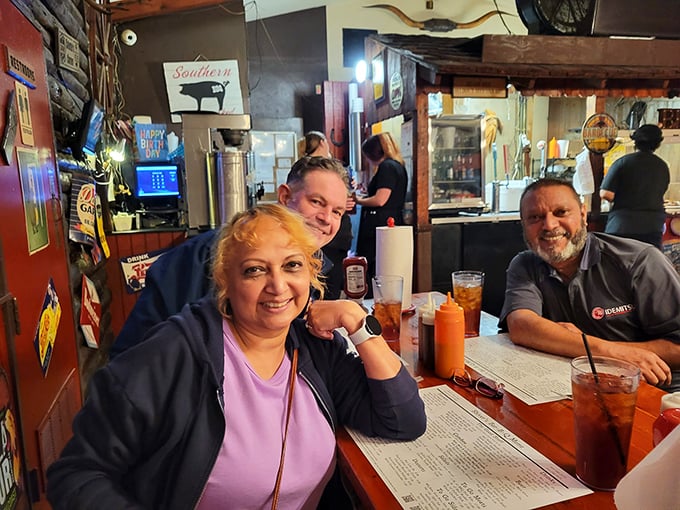 Happy diners sharing stories and sauce-stained smiles. The universal language of barbecue brings people together better than any formal dinner ever could.