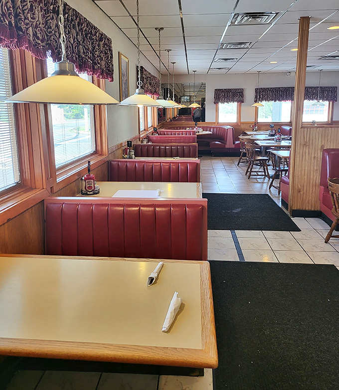 Pendant lights cast a warm glow over red booths and wooden tables, creating that "everybody knows your name" atmosphere that keeps locals coming back.