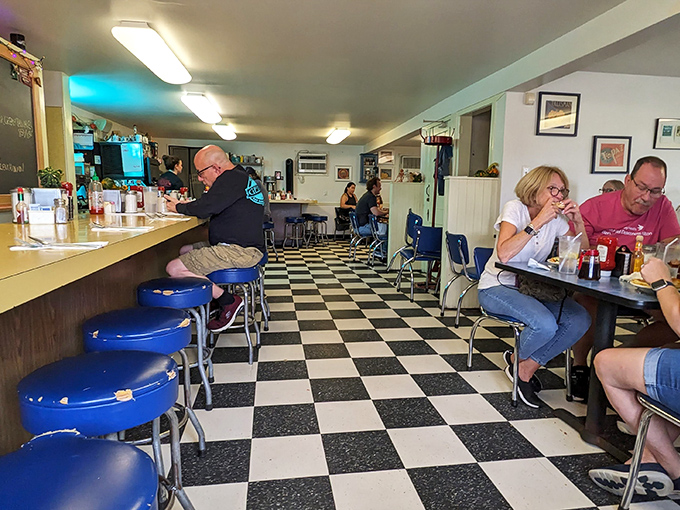Where breakfast magic happens. Blue stools line the counter while the checkerboard floor leads you to tables where pancake dreams come true.