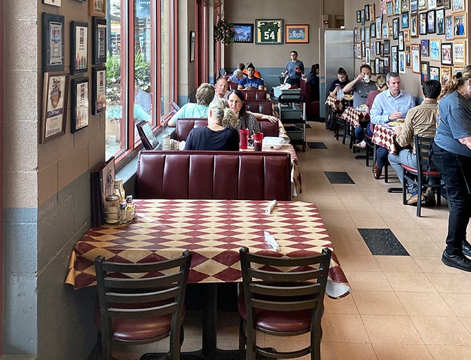 Red booths and checkered tablecloths create the classic diner atmosphere where breakfast dreams come true and calories don't count.