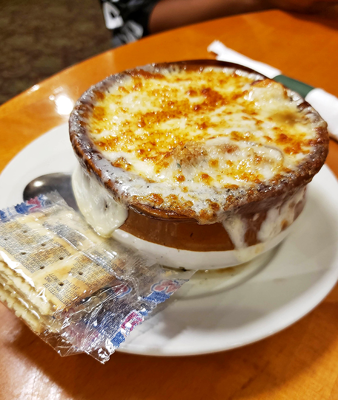French onion soup with a cheese cap so perfect it deserves its own superhero cape. Crackers standing by for the inevitable dunk.