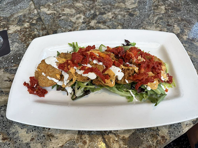 Fried green tomatoes dressed for success with what appears to be crab and remoulade. Southern tradition getting the red-carpet treatment it deserves.