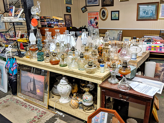 Oil lamps and vintage glassware create a museum-like display. These illuminating artifacts tell stories of evenings before electricity.