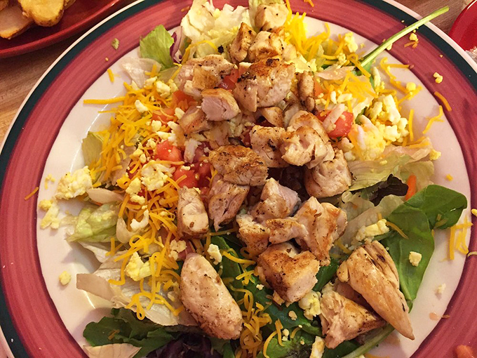 When salad actually satisfies: grilled chicken and shredded cheese transform ordinary greens into something worth celebrating.