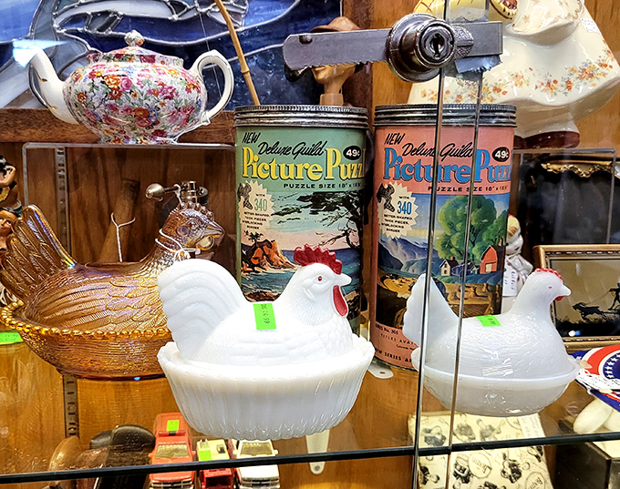 Vintage milk glass chicken dishes perch beside retro puzzle tins, creating the kind of eclectic vignette that defines flea market magic.